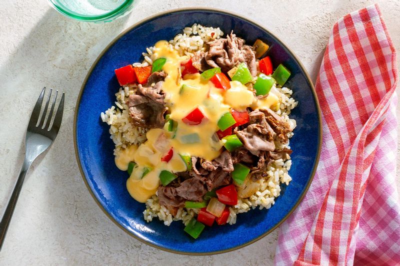 Philly-Style Steak and Peppers With Cheese Sauce Over Brown Rice ...